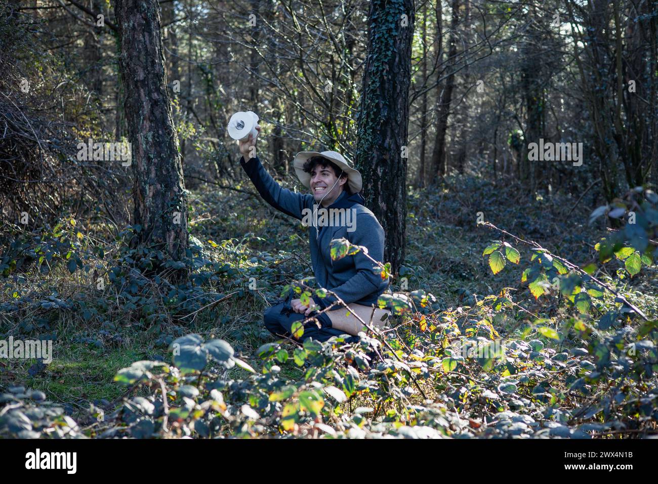 A man dressed as an explorer is depicted defecating behind bushes in ...