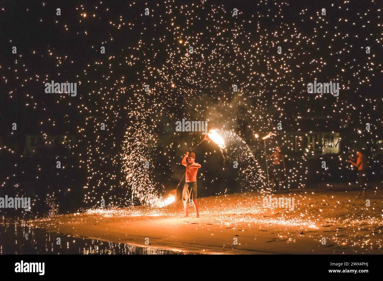 A fire dancer is seen doing fire curving with a fire torch, at night ...