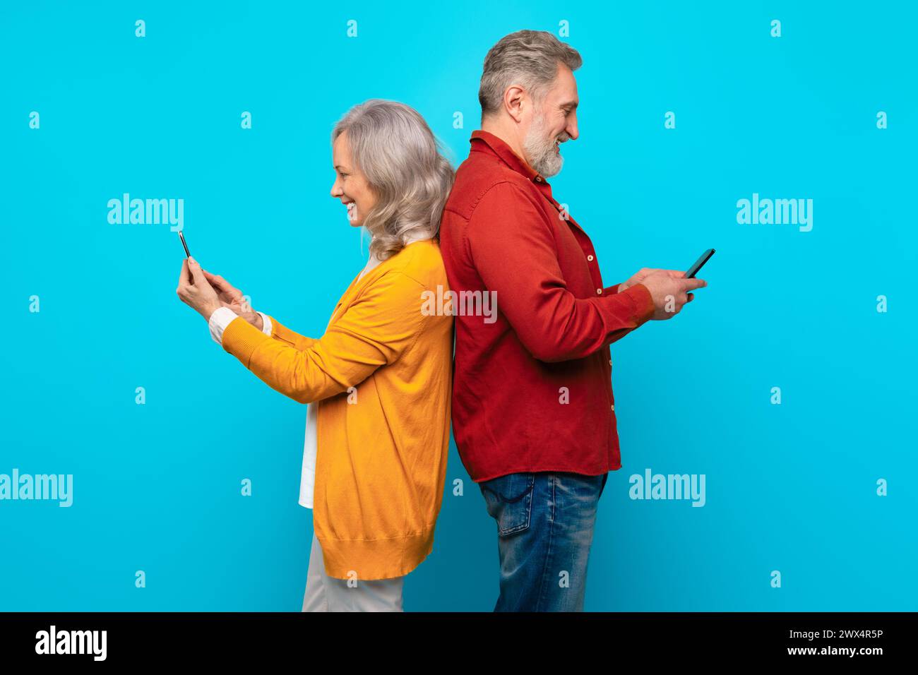 Elderly man and woman scrolling on their cell phones, studio Stock Photo - Alamy