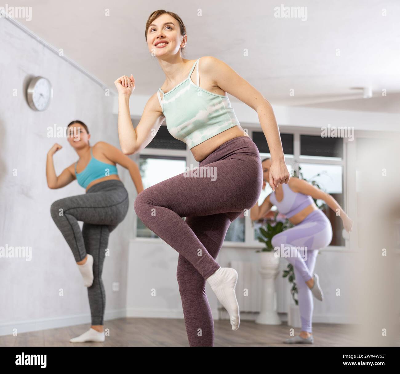 Positive women engaged in active dancing Stock Photo - Alamy