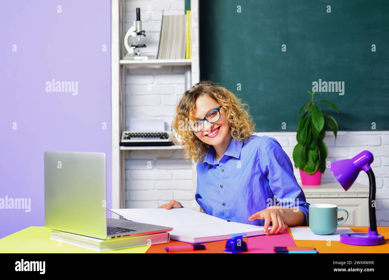 Smiling teacher giving lecture at classroom. Female student studying in ...