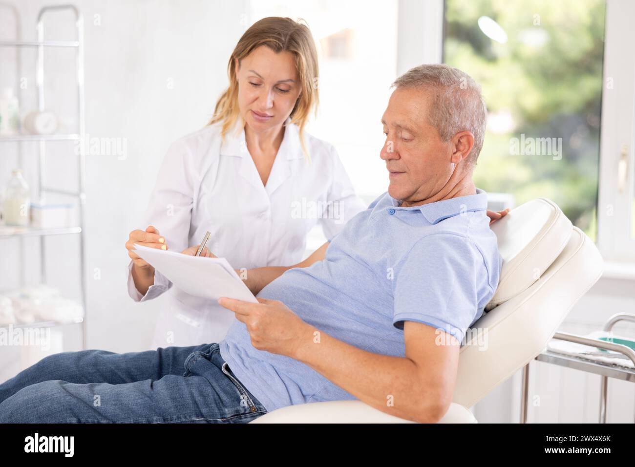 Adult woman doctor giving contract to patient for signing Stock Photo ...