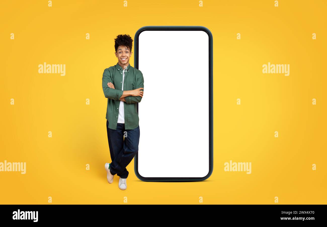 Man leaning on giant smartphone mockup Stock Photo - Alamy
