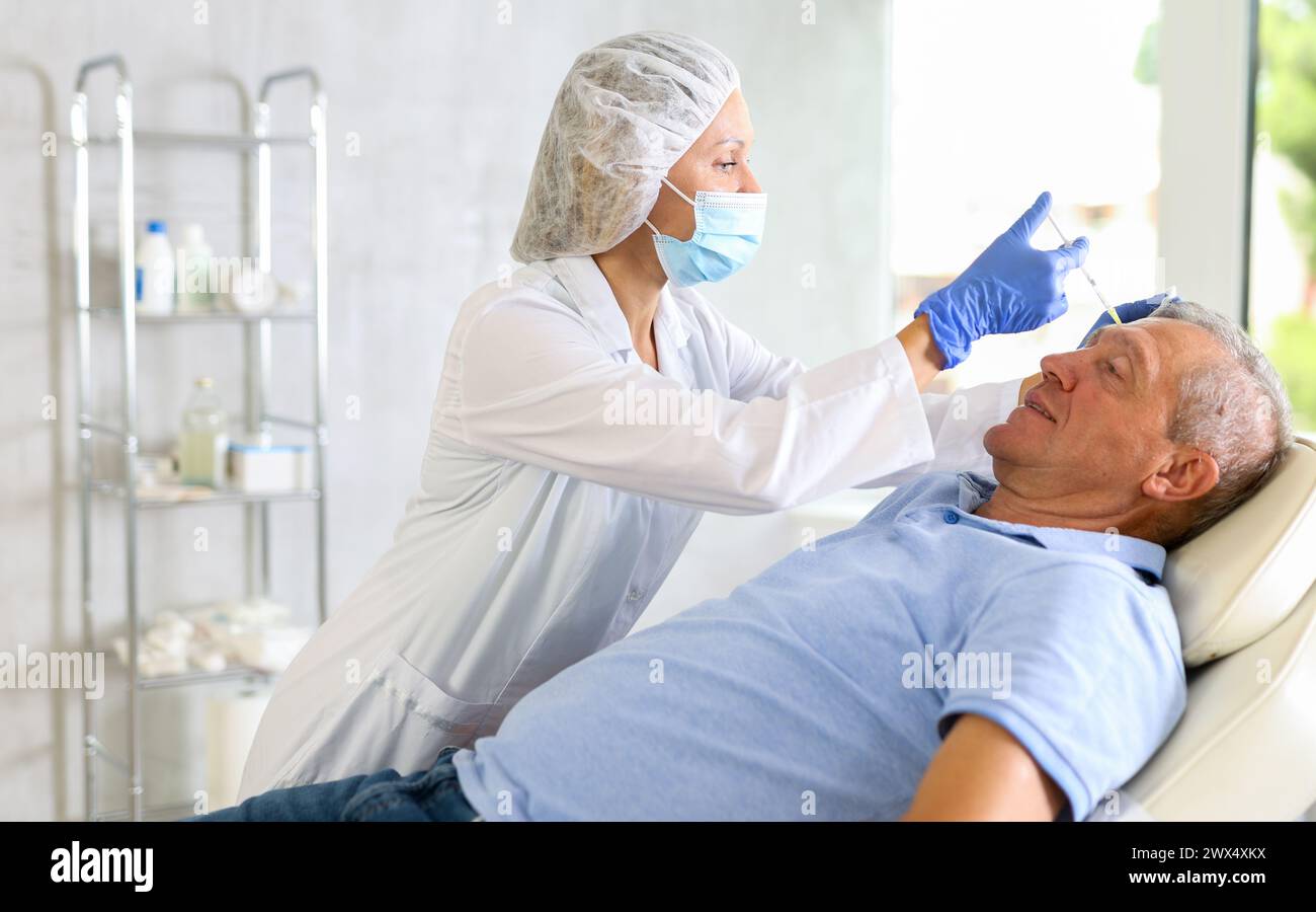 Doctor performs procedure of injectable correction of wrinkles in nasal ...