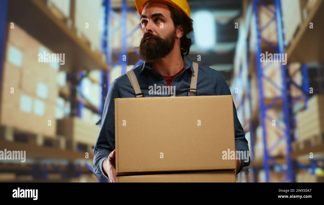 Stock administrator placing boxes on industrial racks based on delivery ...