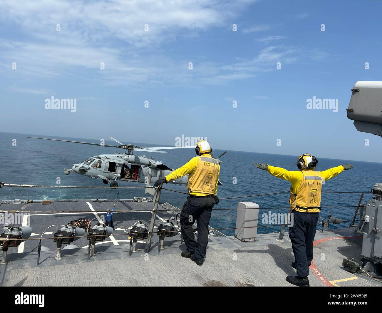 240323-N-NO146-1001 ARABIAN GULF (March 23, 2024) Sailors signal to a ...