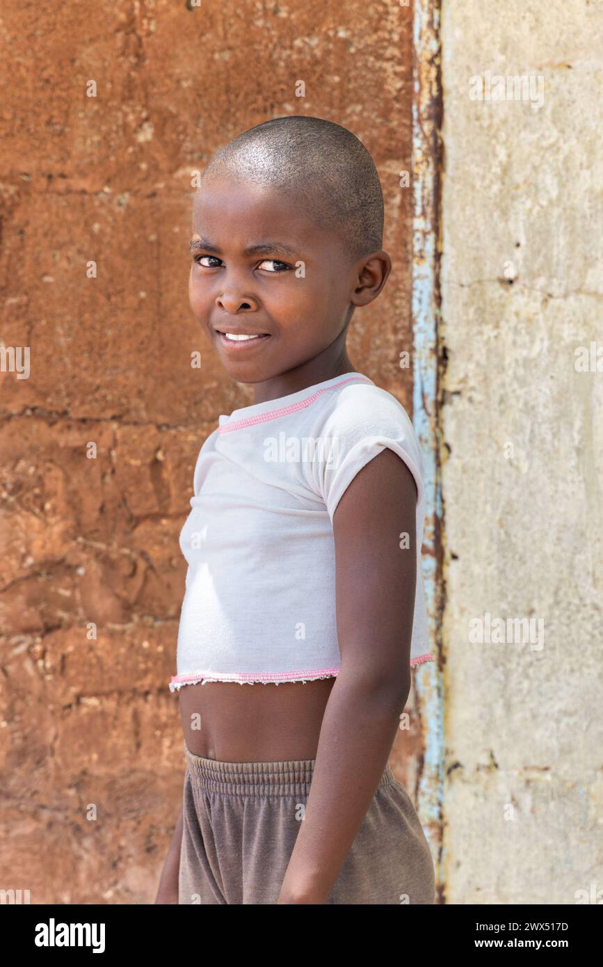 Portrait Of A Single African Villager Girl Standing Outdoors In Front Of The House In A Village