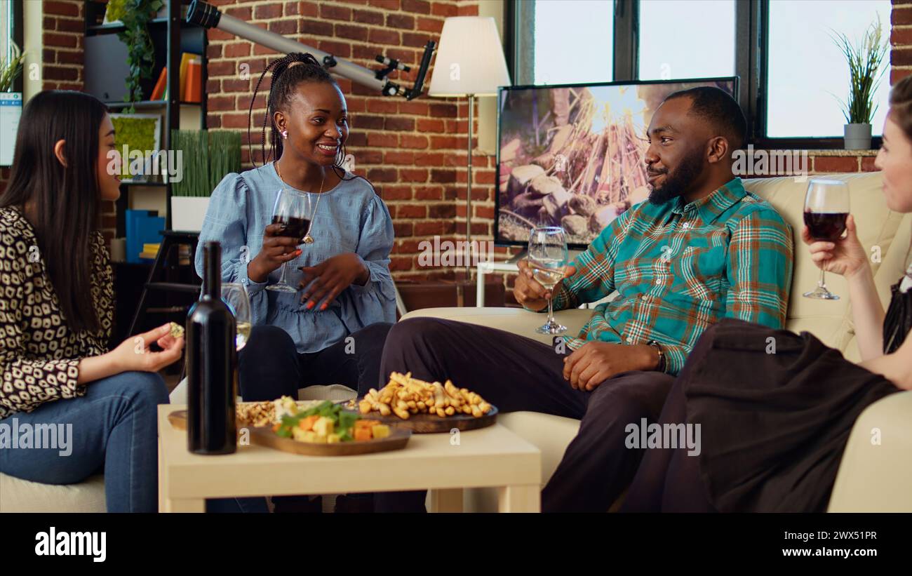 Diverse mates having engaging conversation during apartment party in ...