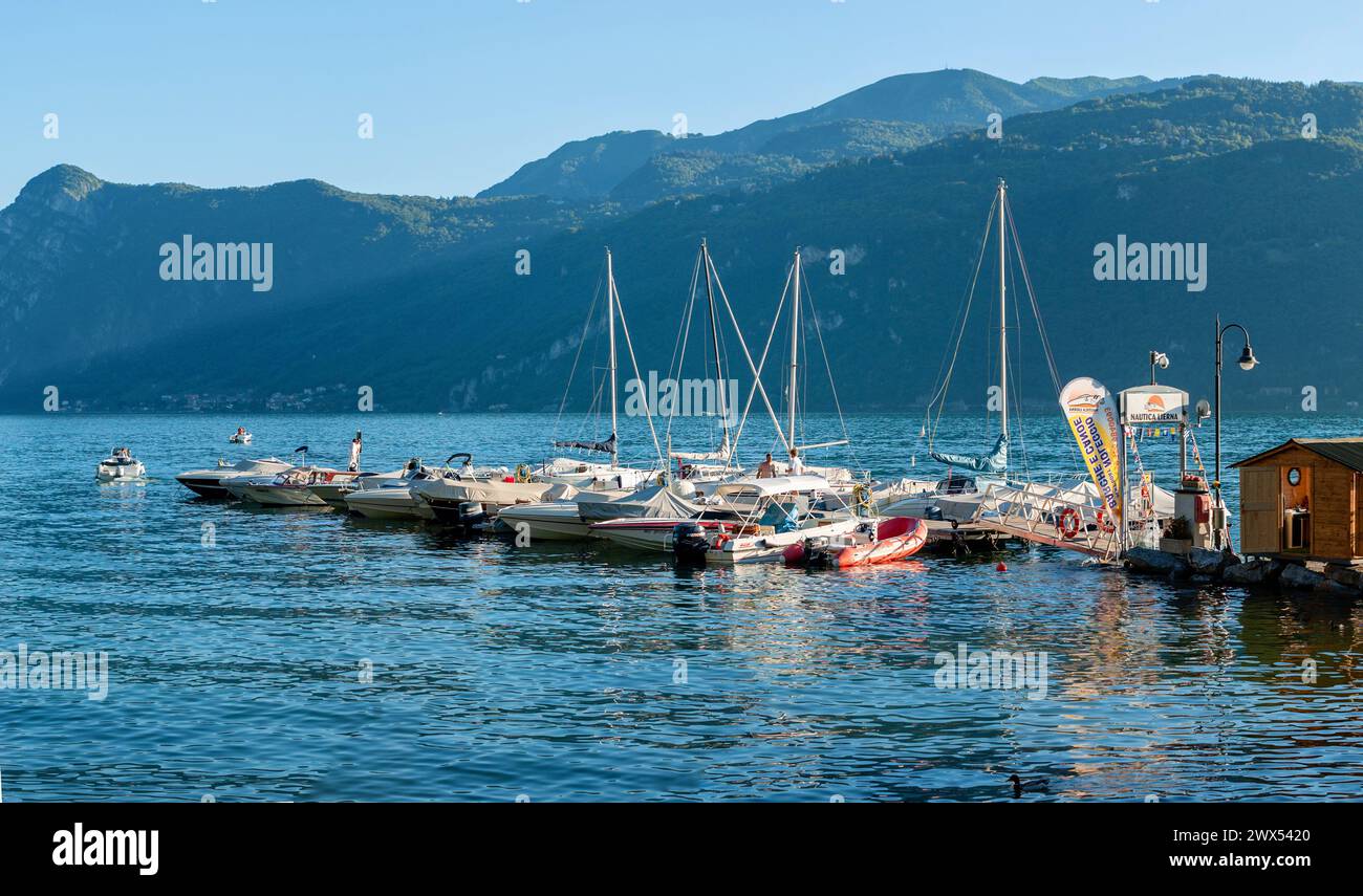 Pier and boats docked at marina on Lake Como in the harbor of the city ...