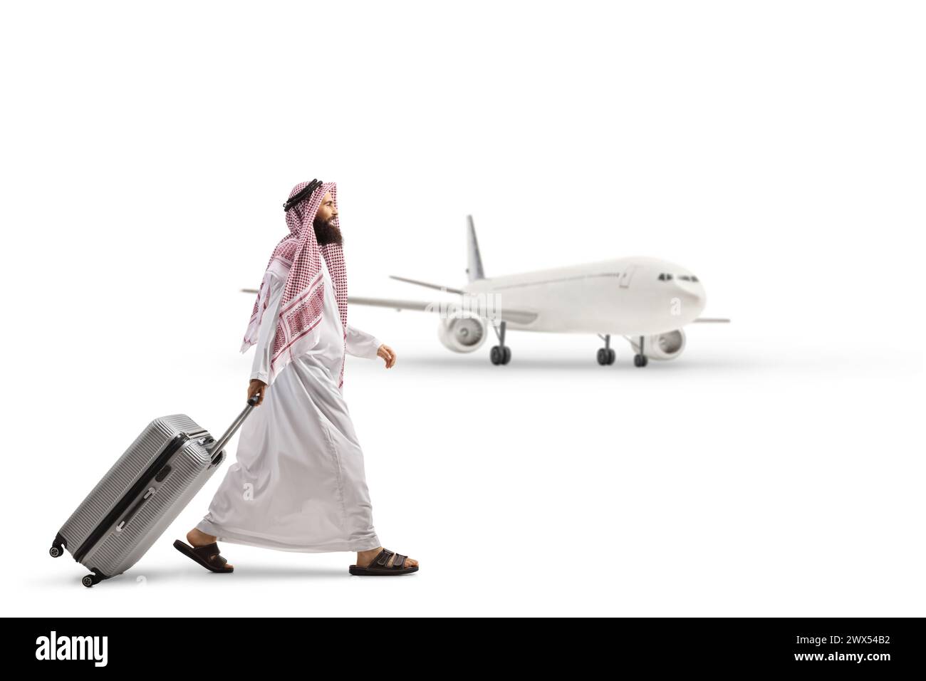 Full length profile shot of a saudi arab man walking and pulling a ...