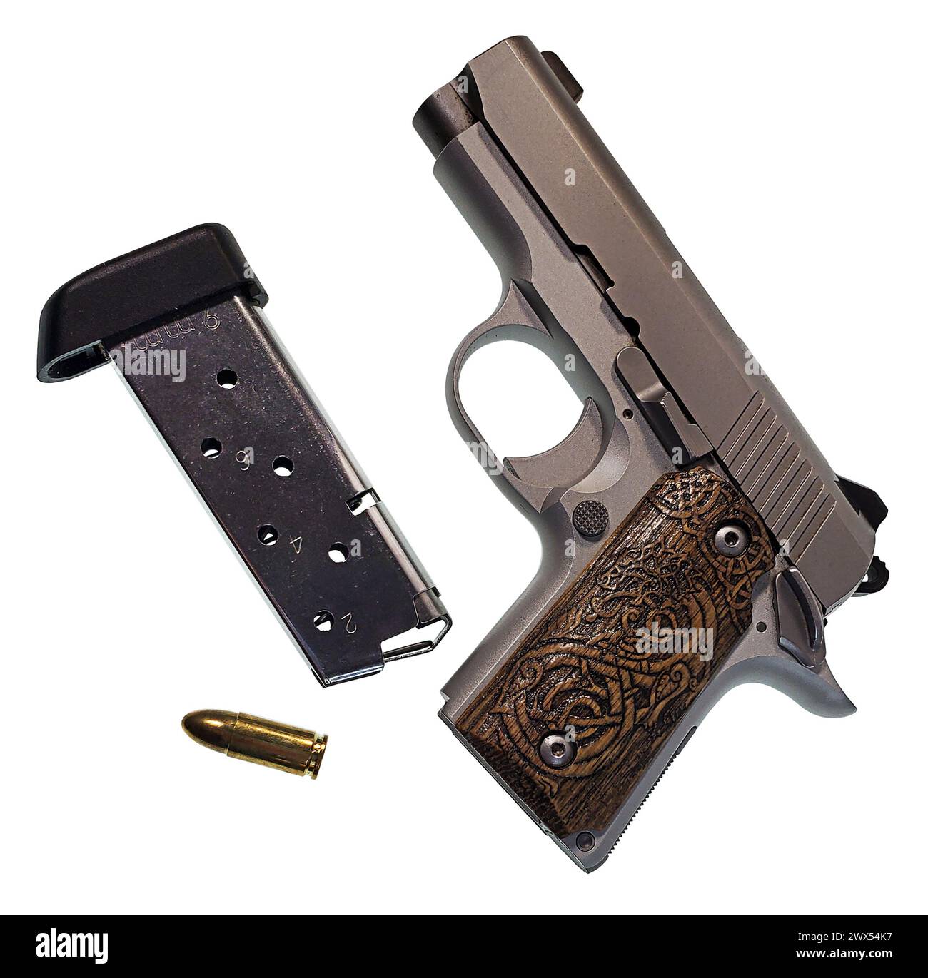 Silver metal gun with Celtic Engraved grip and clip Stock Photo - Alamy