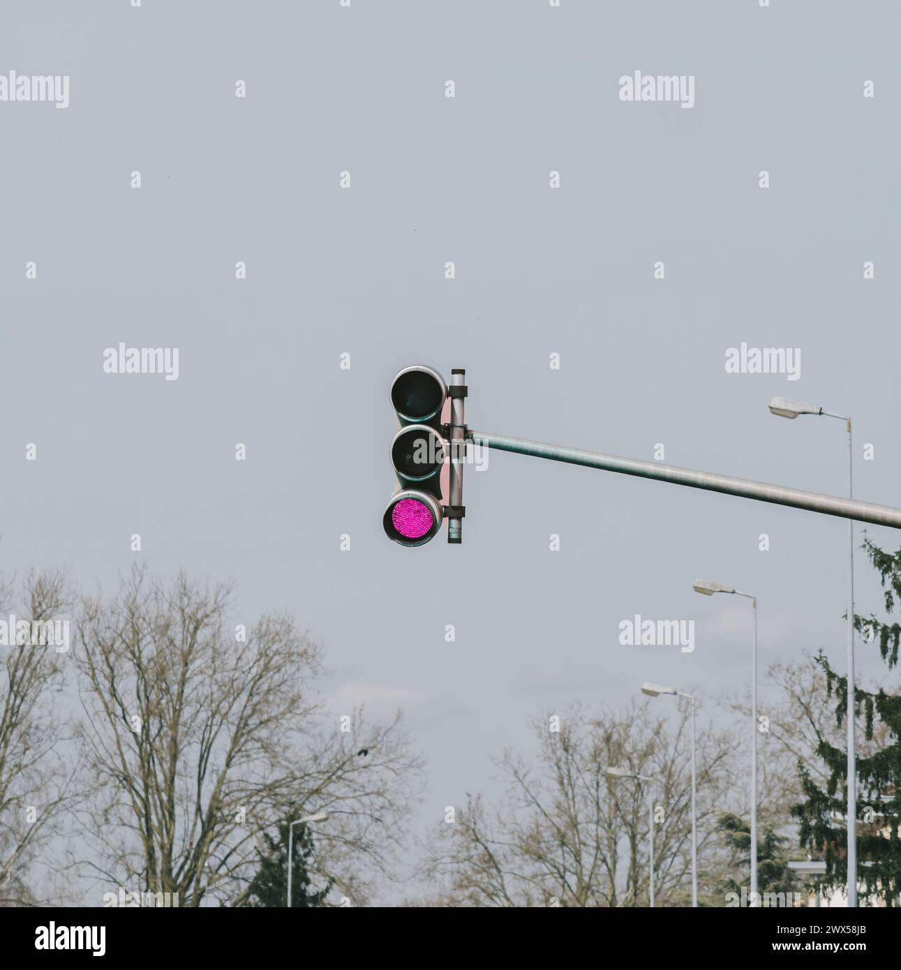 A traffic light suspended from the side of a pole in an urban setting ...