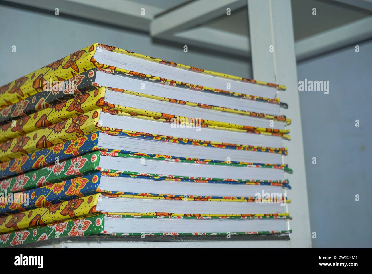 Photo of several books being opened and stacked on a reading shelf ...