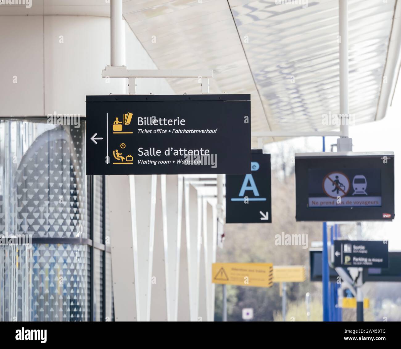 Multilingual sign at a French train station indicating directions to ...