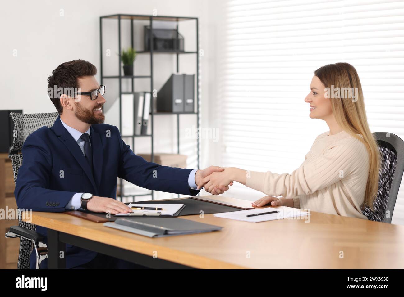 Lawyer shaking hands with client in office Stock Photo - Alamy