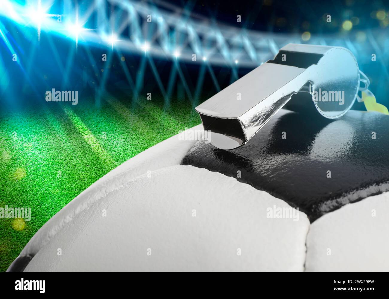 Referee equipment. Soccer ball and whistle on green football field ...