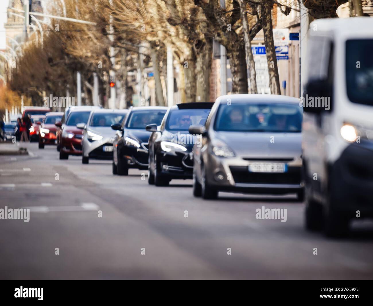 A long line of cars stretches down a busy city street, causing ...
