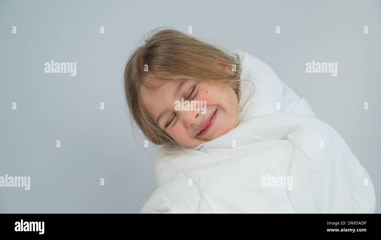 Portrait of a cute little girl wrapped in a white blanket Stock Photo ...