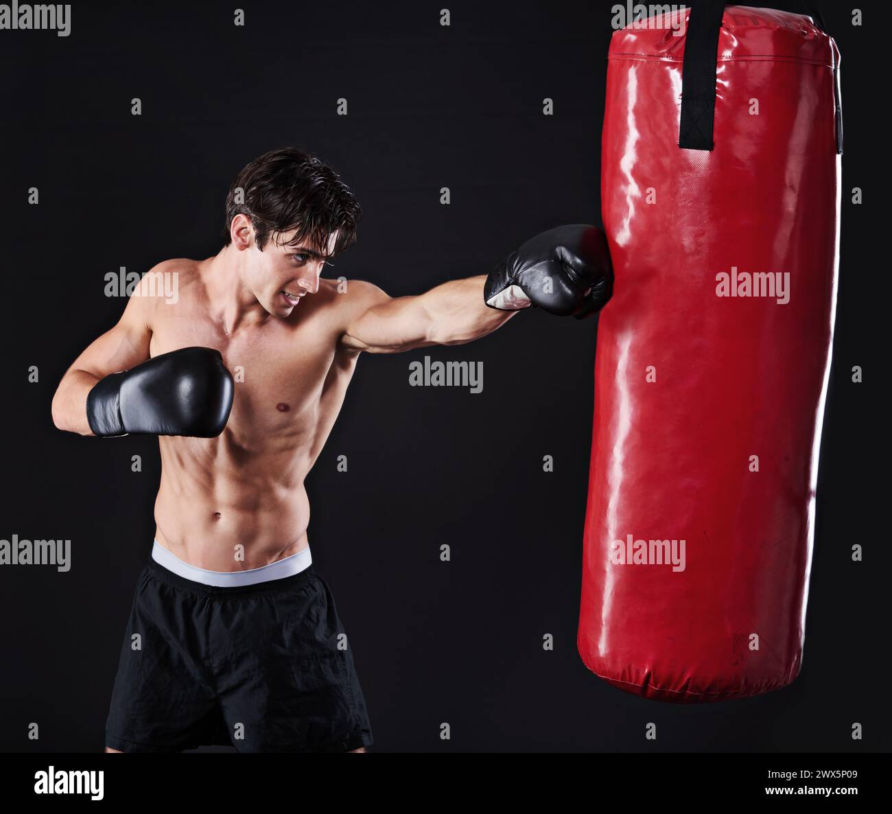 Man, athlete and punch on boxing bag with gloves for exercise workout ...