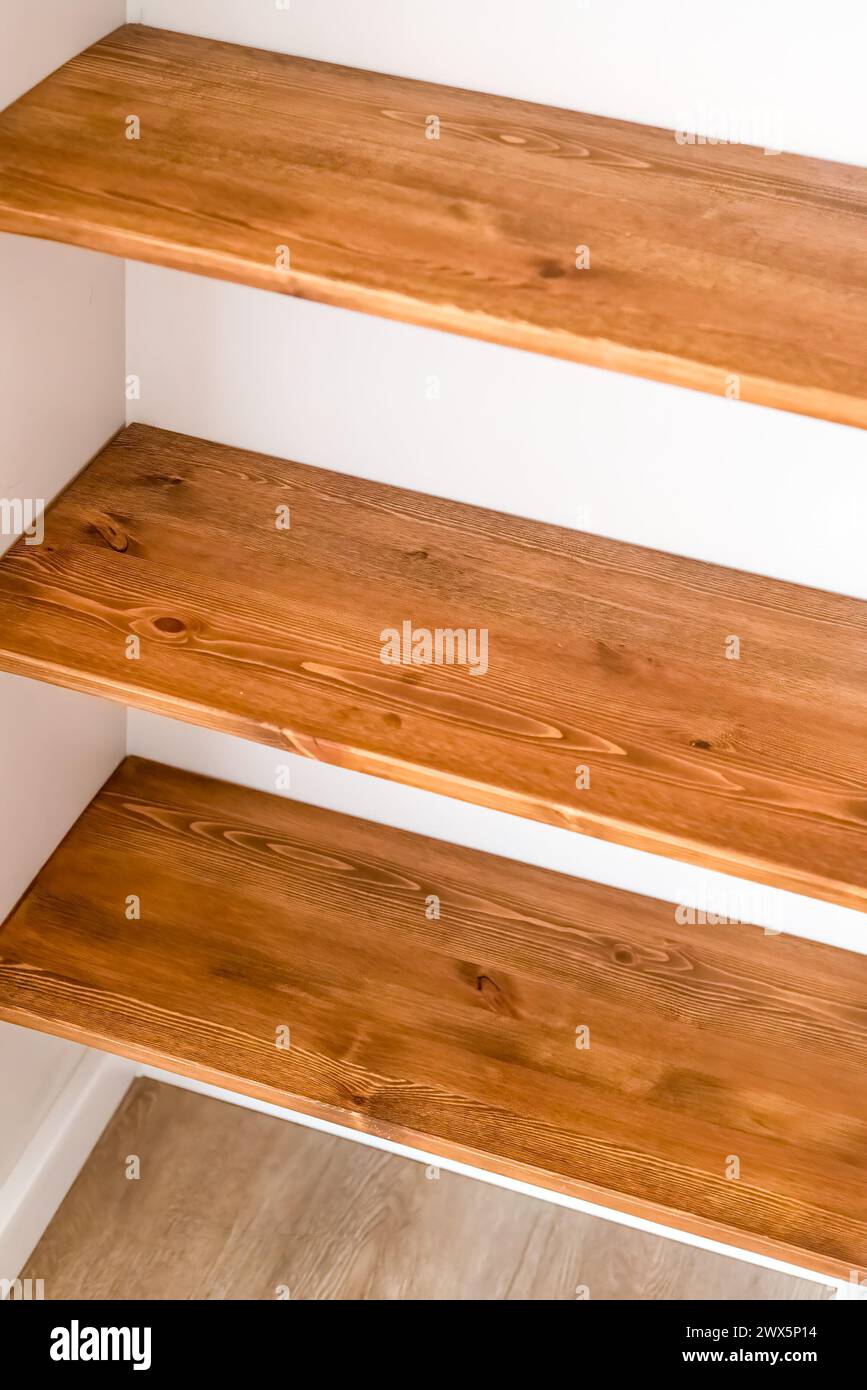 three empty wooden shelves on a white wall Stock Photo - Alamy