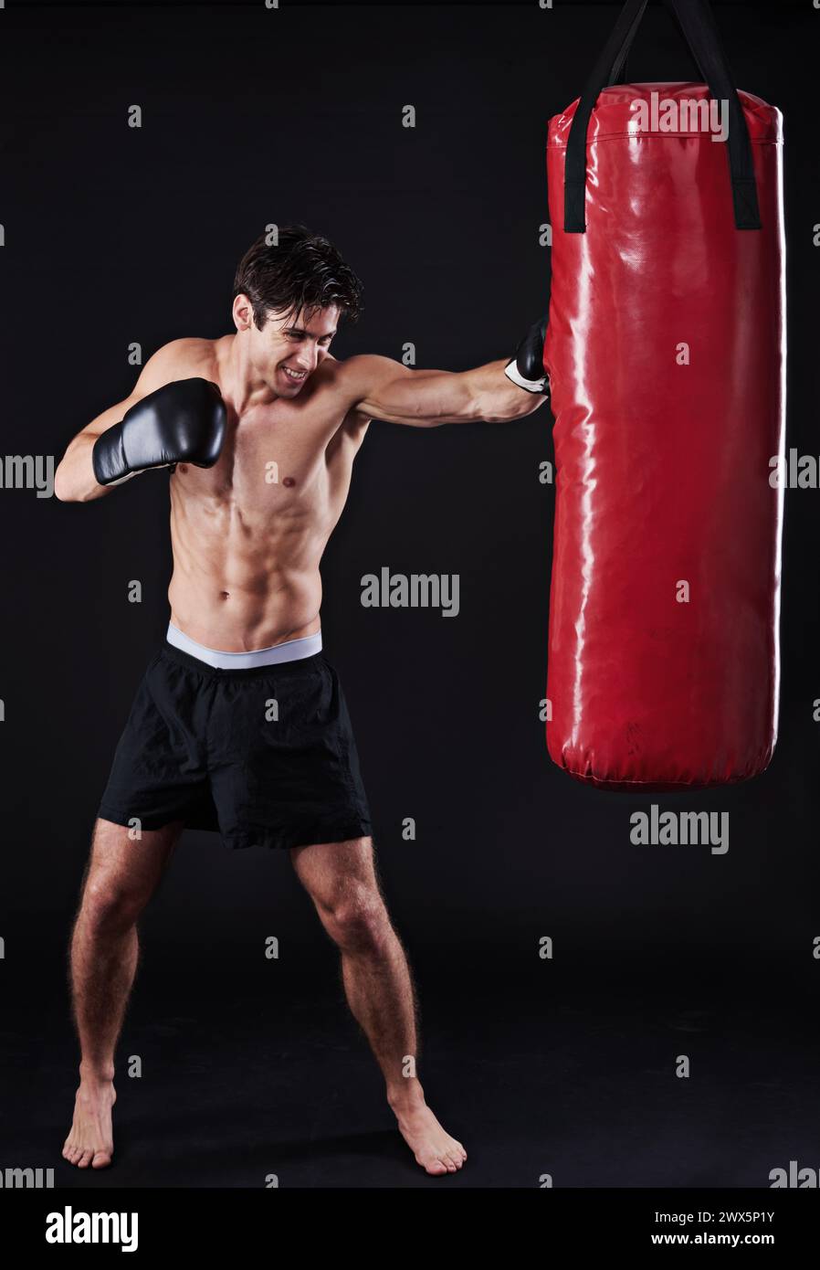 Boxer, man and punch in studio with boxing bag for workout, exercise or ...