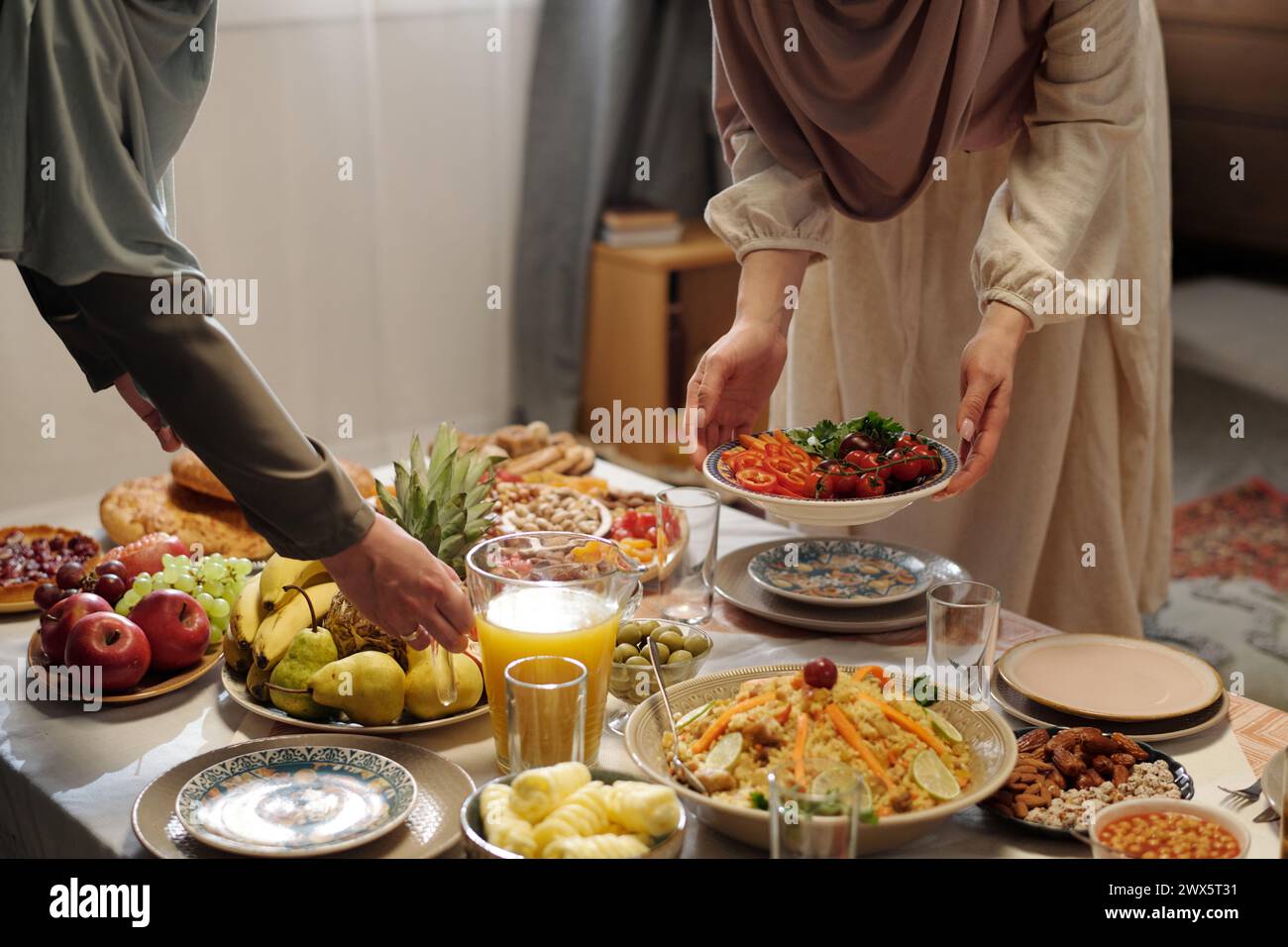 Two unrecognizable Muslim women wearing plain dresses and hijabs ...