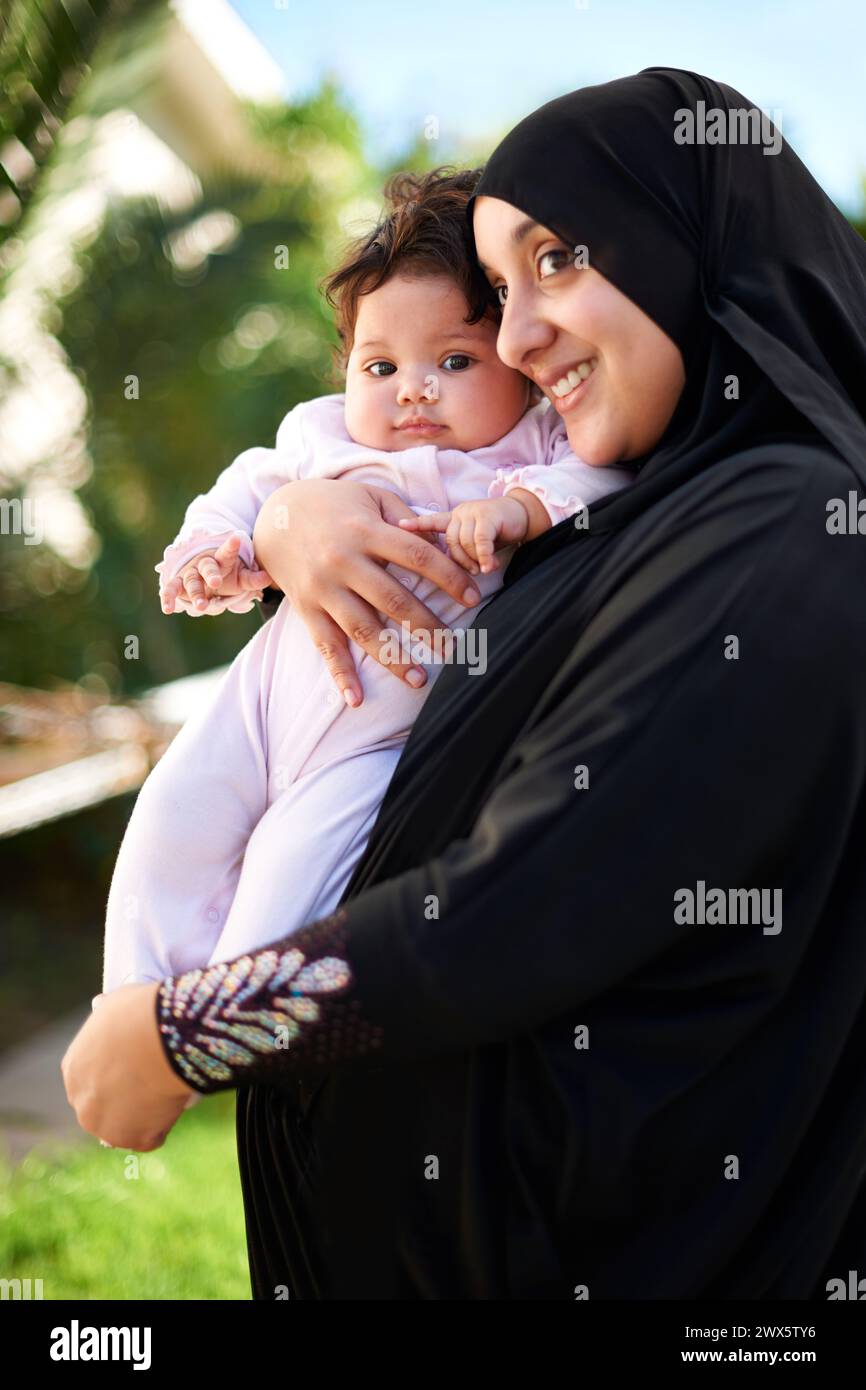 Muslim, woman and baby happy outdoor, hug in garden with mother and ...