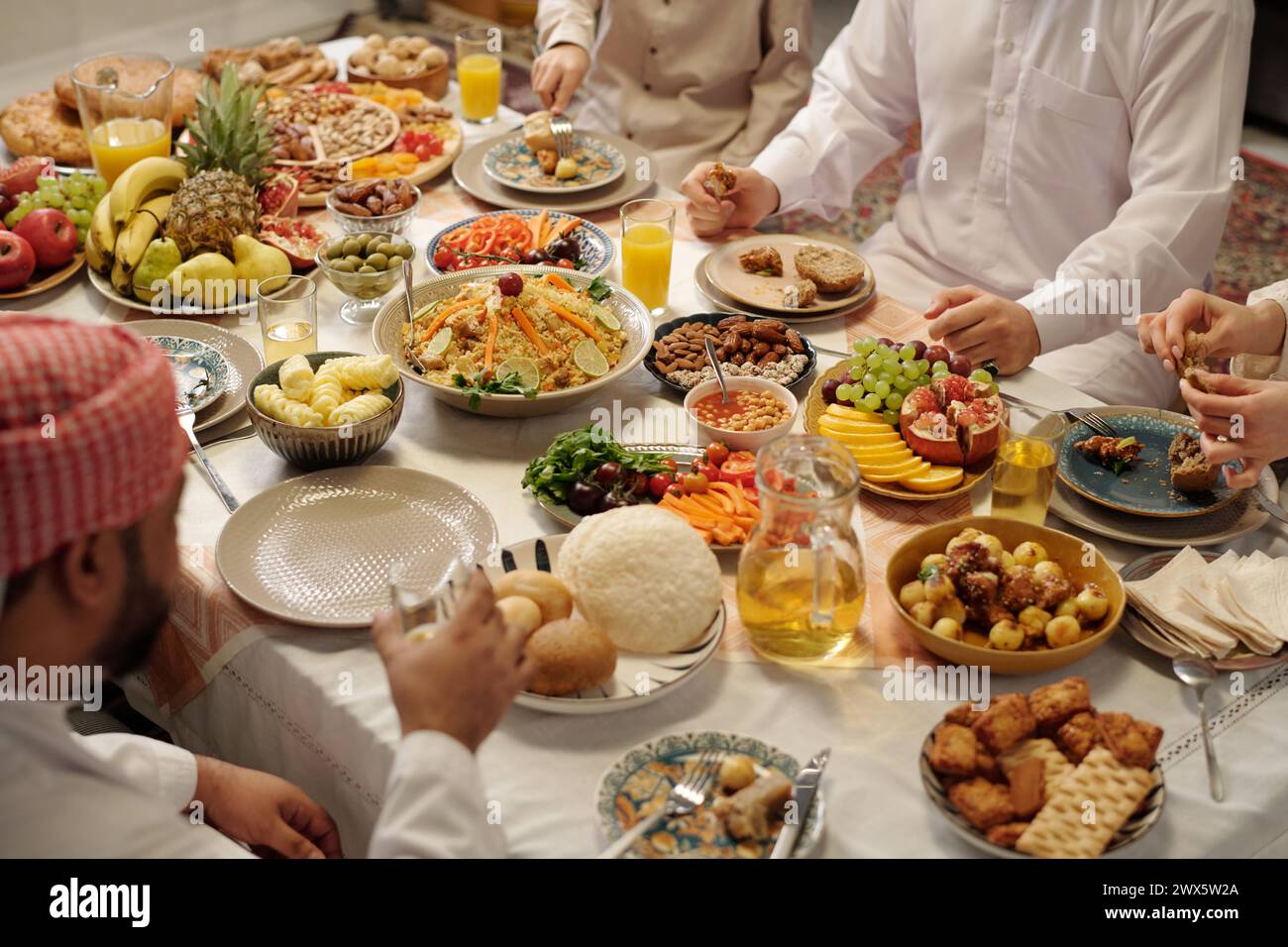High angle vie of unrecognizable Muslim family sitting at abundant ...