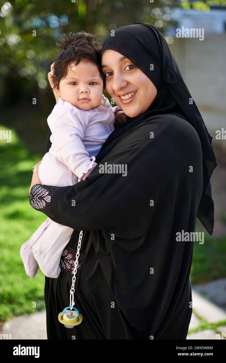Muslim, woman and baby with smile outdoor, portrait in garden with ...