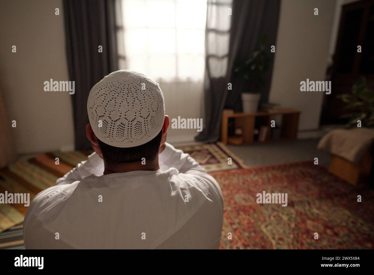 Rear view shot of unrecognizable male Muslim wearing white thobe with ...