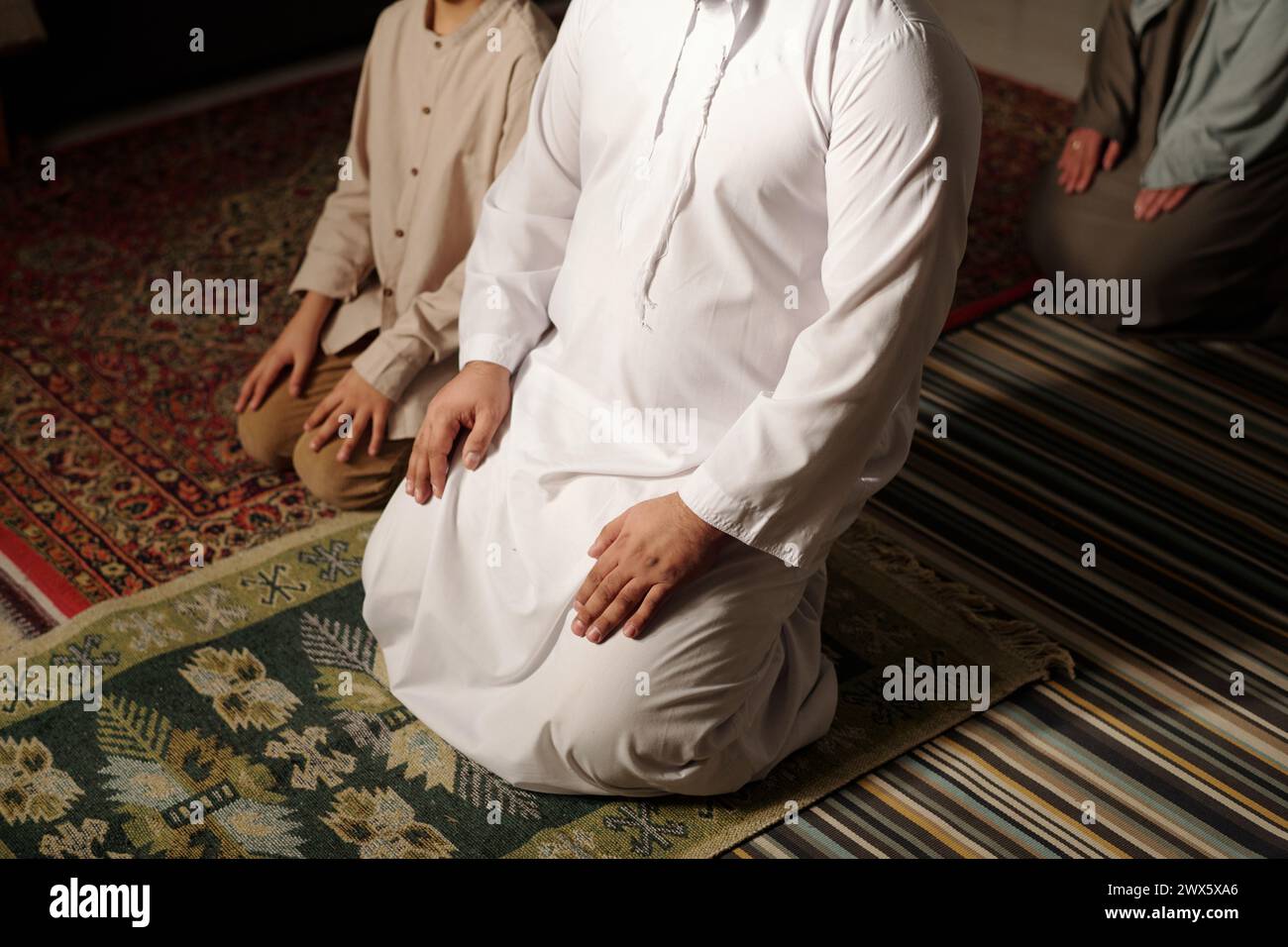 High angle view of unrecognizable Muslim family of three sitting on ...