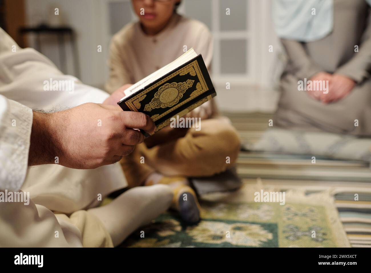 Selective focus closeup of unrecognizable Muslim man reading Quran ...