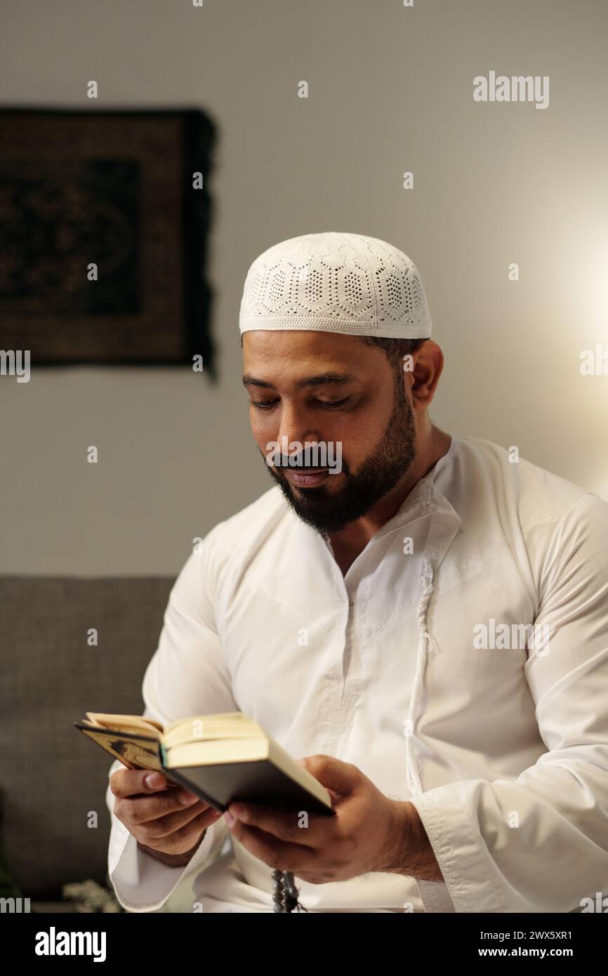 Vertical medium portrait of bearded Muslim man wearing white clothes ...