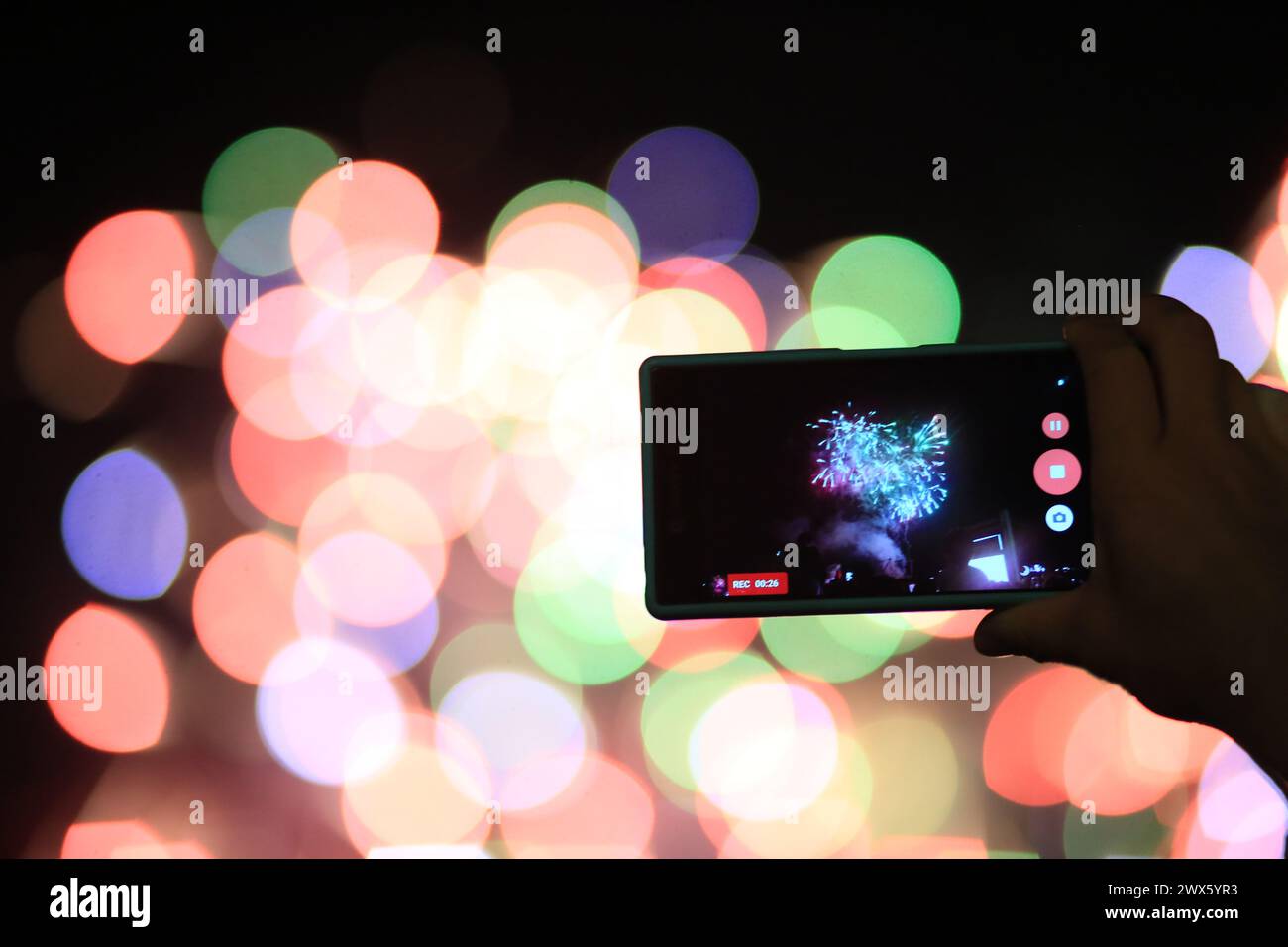 A person captures fireworks with a smartphone camera Stock Photo - Alamy