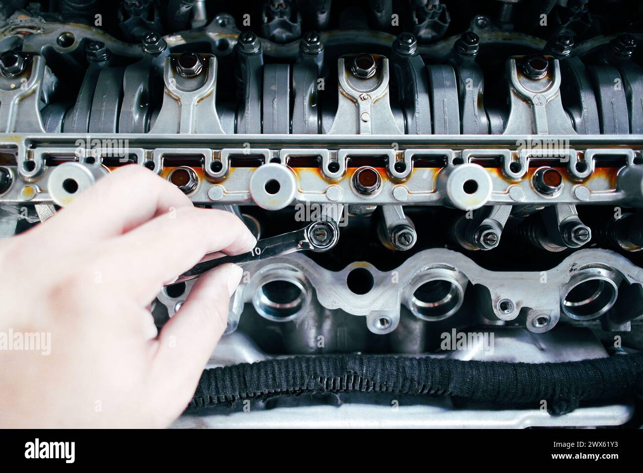 Car mechanic checking and adjusting valves of car engine, Car ...