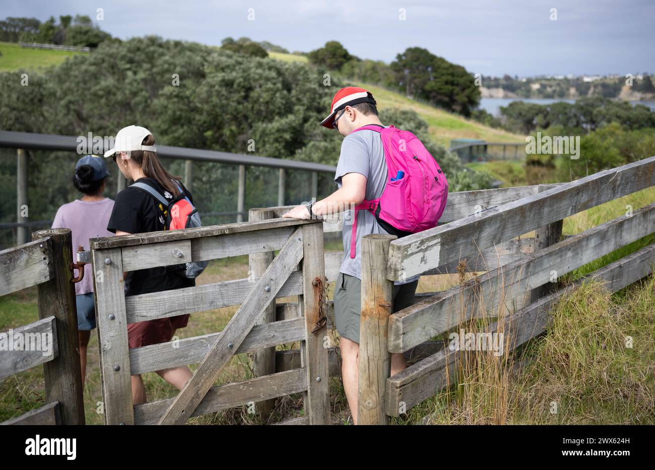 People walking through the farm gate on a hiking track. Leave gates as ...