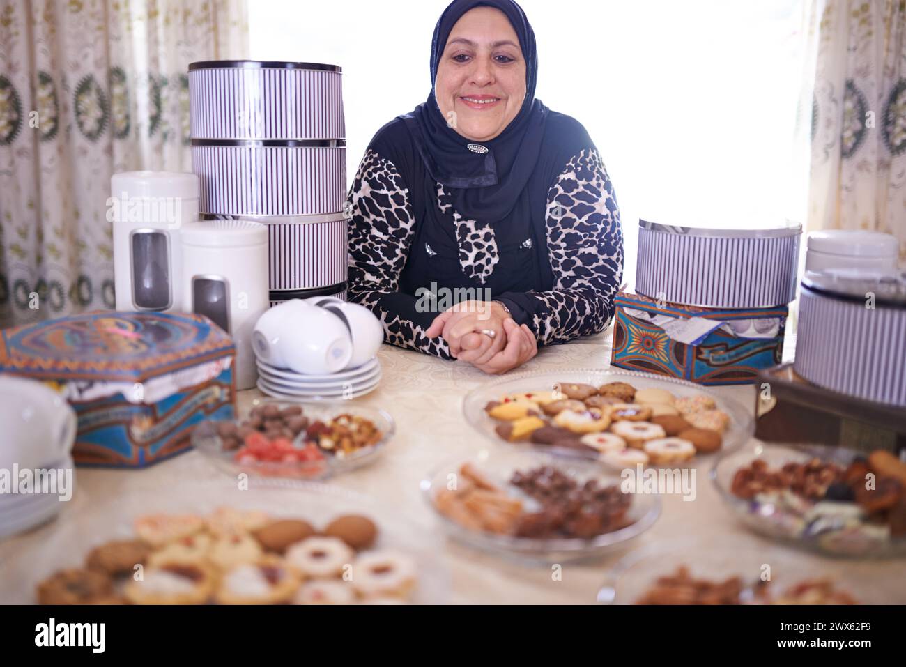Woman, Muslim and cakes in house for celebration, cheerful and dining ...