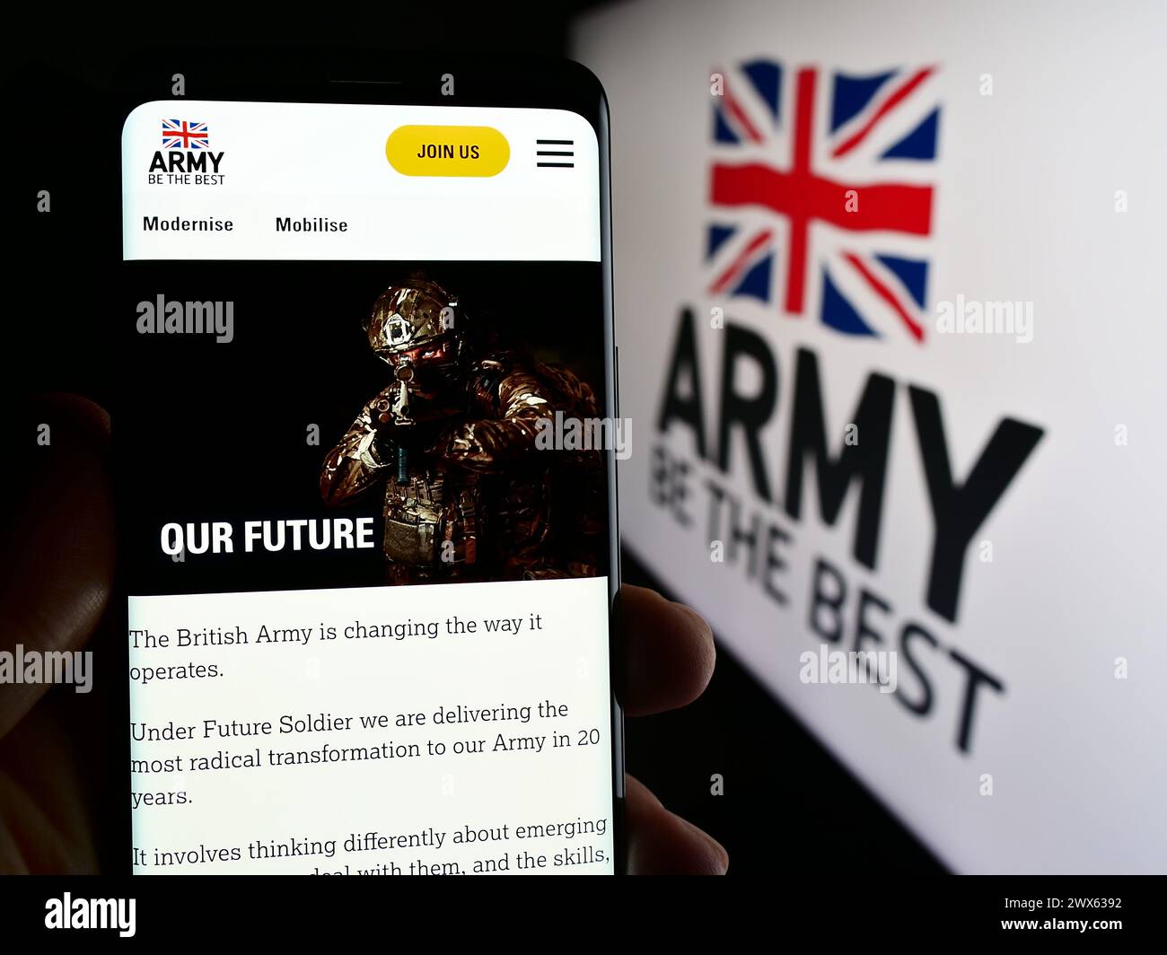 Person holding mobile phone with web page of United Kingdom ground ...