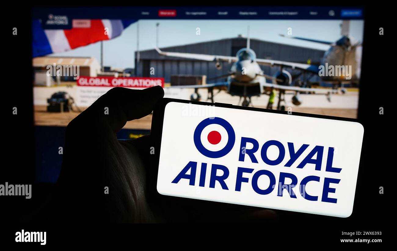 Person holding smartphone with logo of United Kingdom air and space force Royal Air Force (RAF ...