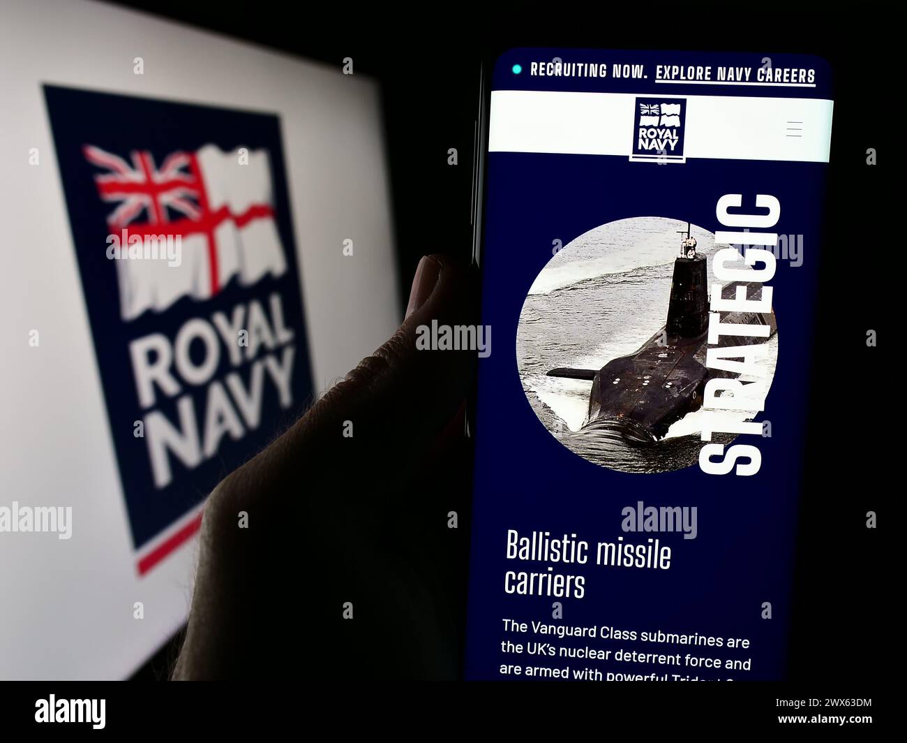 Person holding cellphone with webpage of United Kingdom naval warfare ...