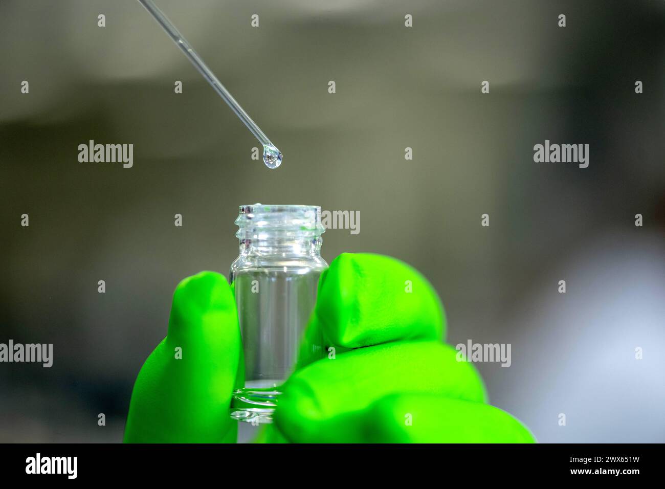 Holding a test tube and dipping some solution inside Stock Photo - Alamy