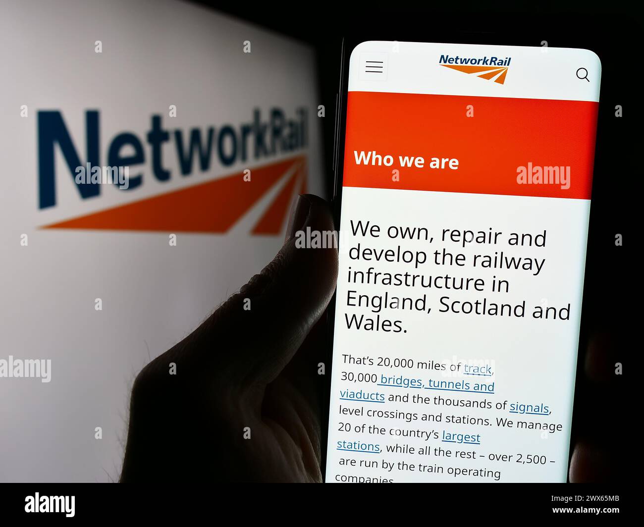 Person holding cellphone with webpage of railway infrastructure company ...