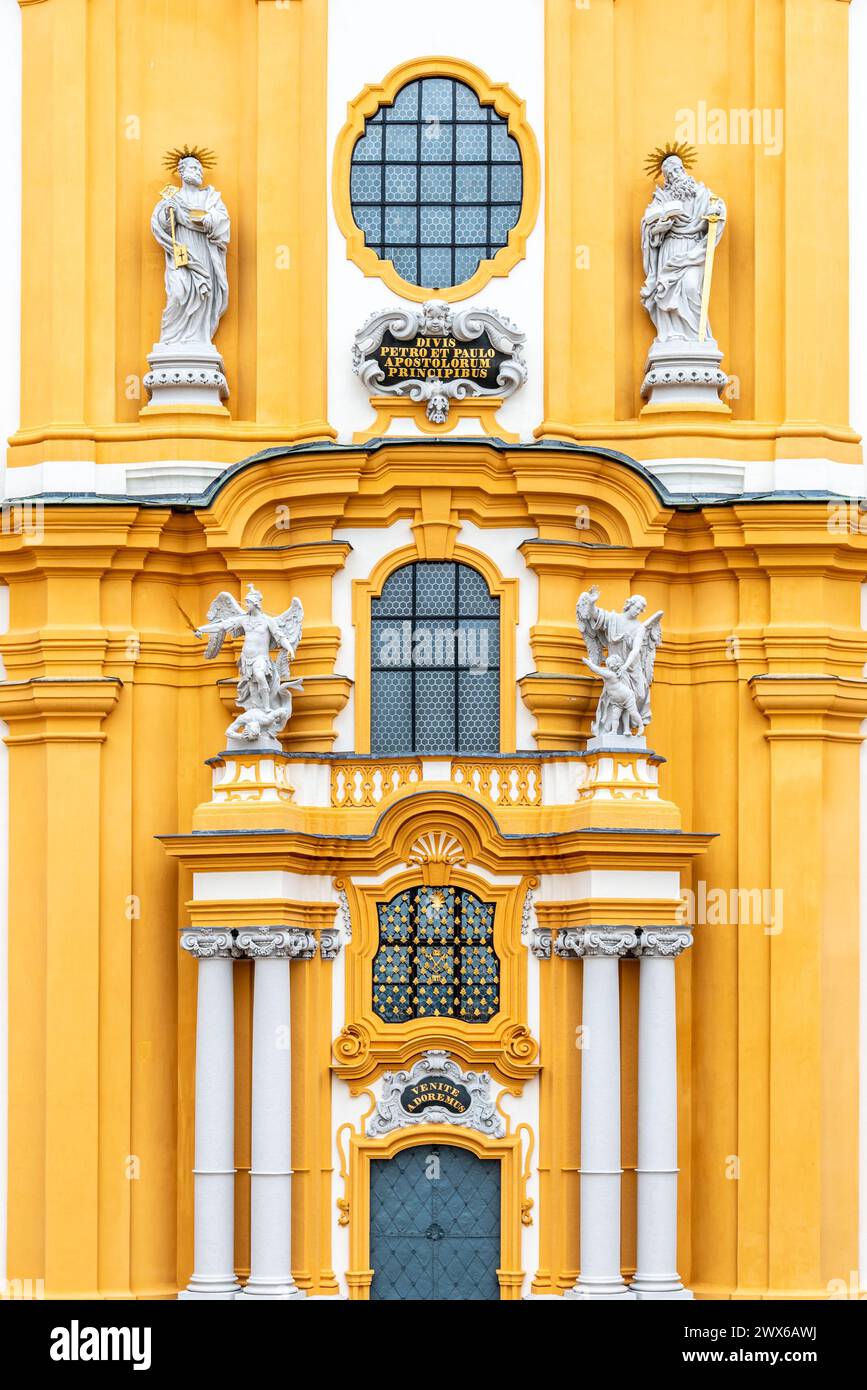 The ornate yellow and white baroque facade of Melk Abbey, adorned with ...