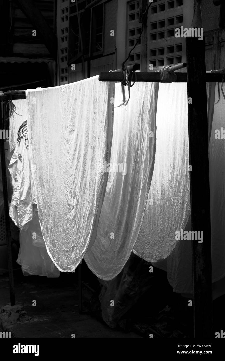 Three sheets hang in semicircles from three clothes lines in an ...