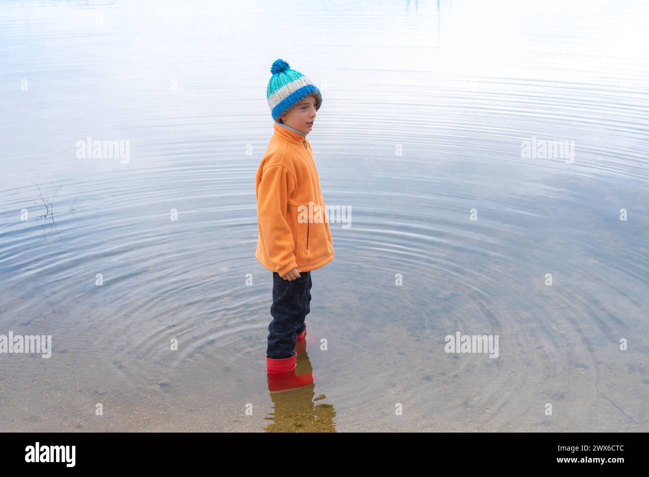 Boy with wellies in a lake Stock Photo - Alamy