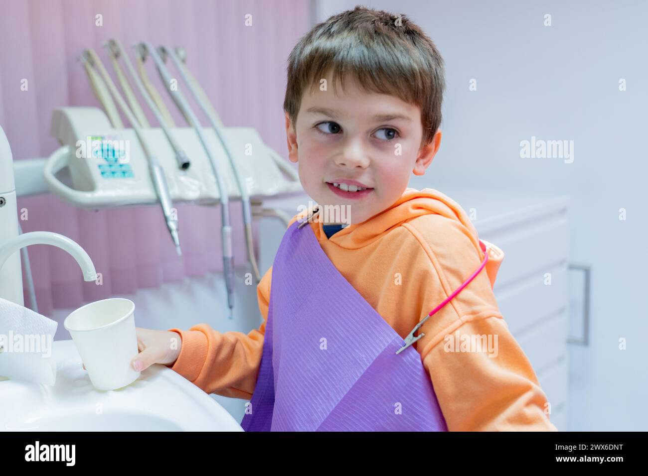 Boy at the dentist's office taking water to rinse his mouth Stock Photo ...