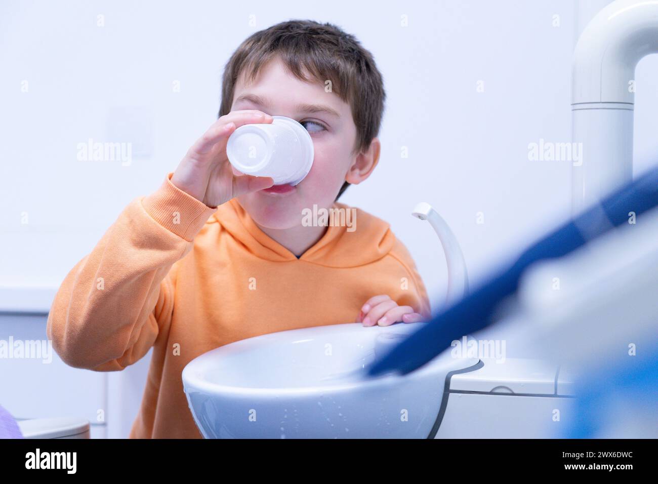 caucasian boy rinsing his teeth at the dentist's office Stock Photo - Alamy