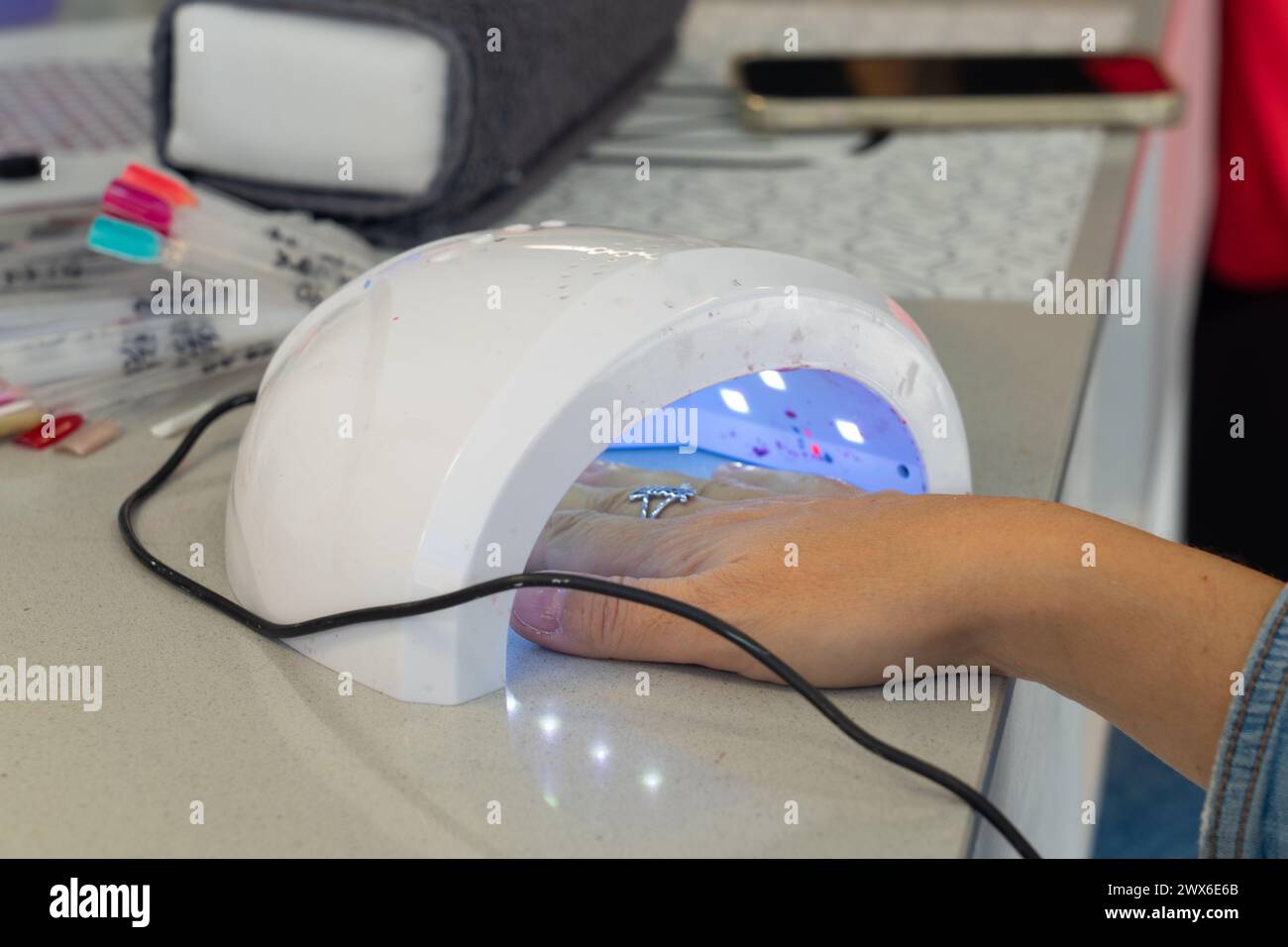 Woman drying her nails in a manicure center Stock Photo - Alamy