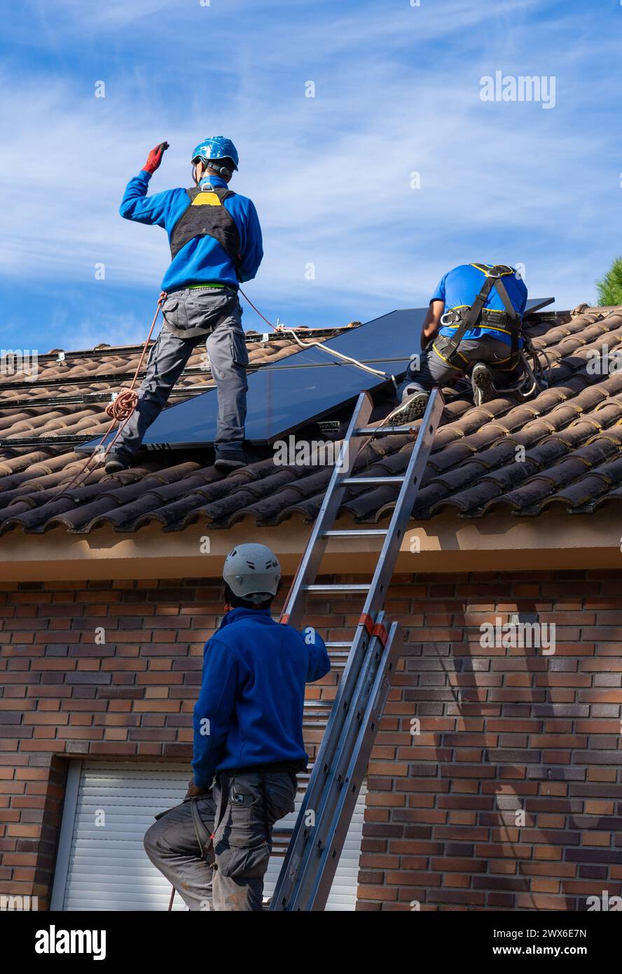 Three workers installing solar panels. Solar energy Stock Photo - Alamy
