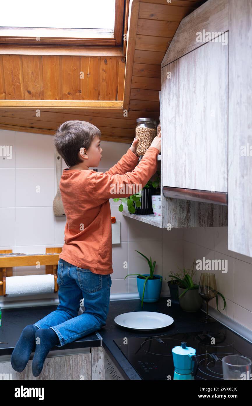 Boy reaching up shelf hi-res stock photography and images - Alamy